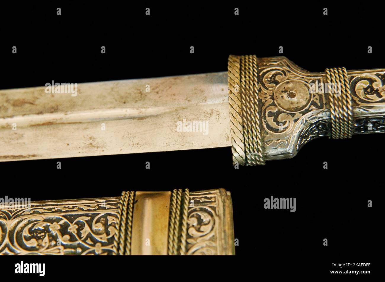 An antique dagger with artistic chasing and engraving on a black ...