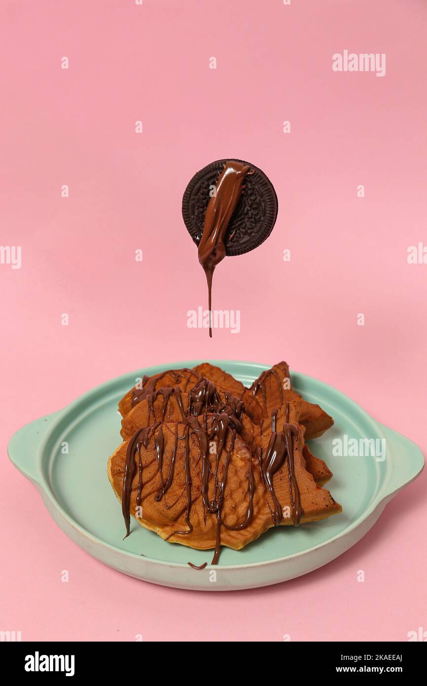 The vertical view of fish-shaped Taiyaki cones on a blue plate with ...