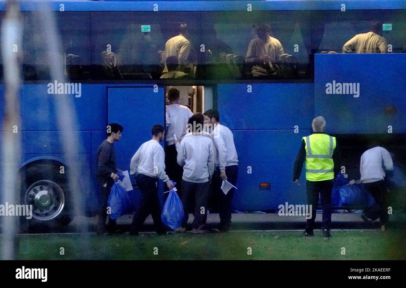 A group of people thought to be migrants gather their belongings before ...
