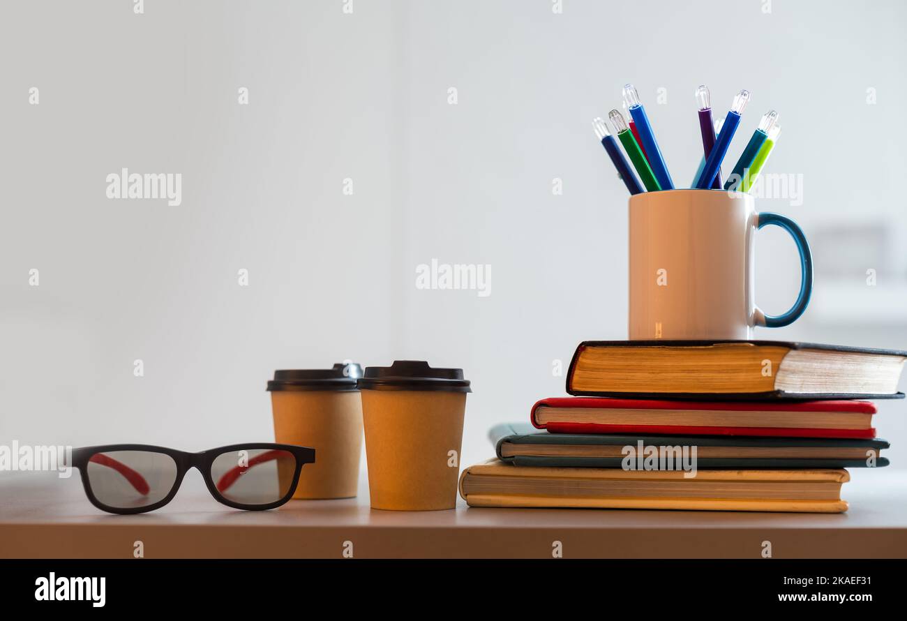 a stack of books and a cup with pencils Stock Photo - Alamy