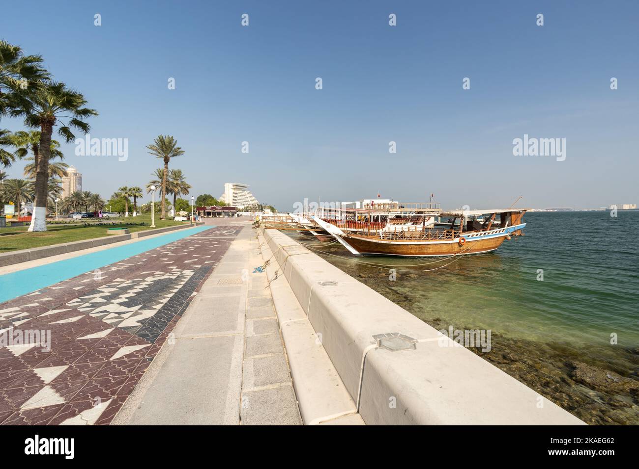 A row of empty old traditional dhow ships docked by the shore at Doha ...