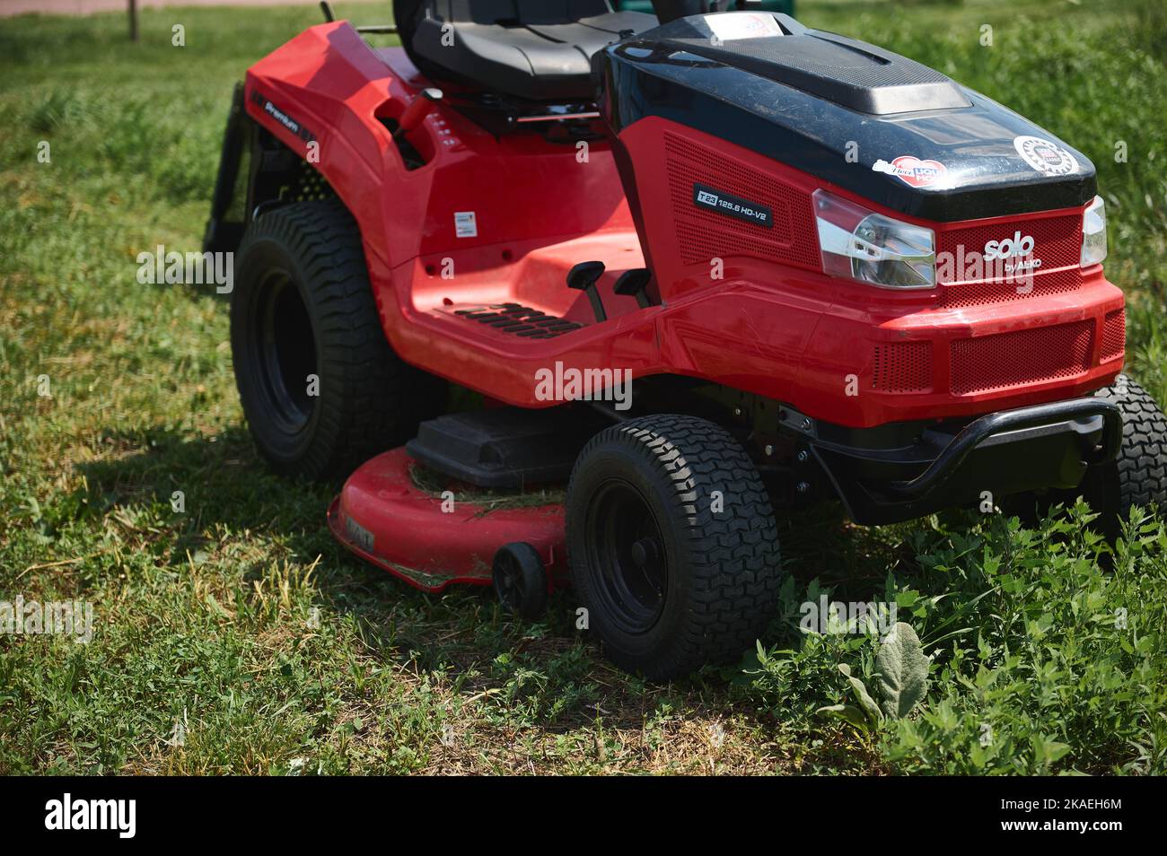 A red lawn mower on the green grass. Electrical equipment for mowing ...