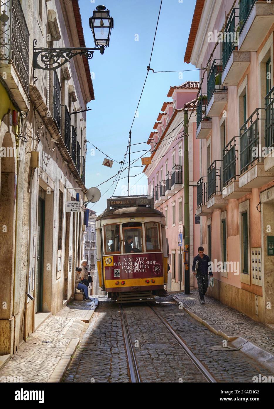 A vertical shot of a cable going through a narrow alley surrounded by ...
