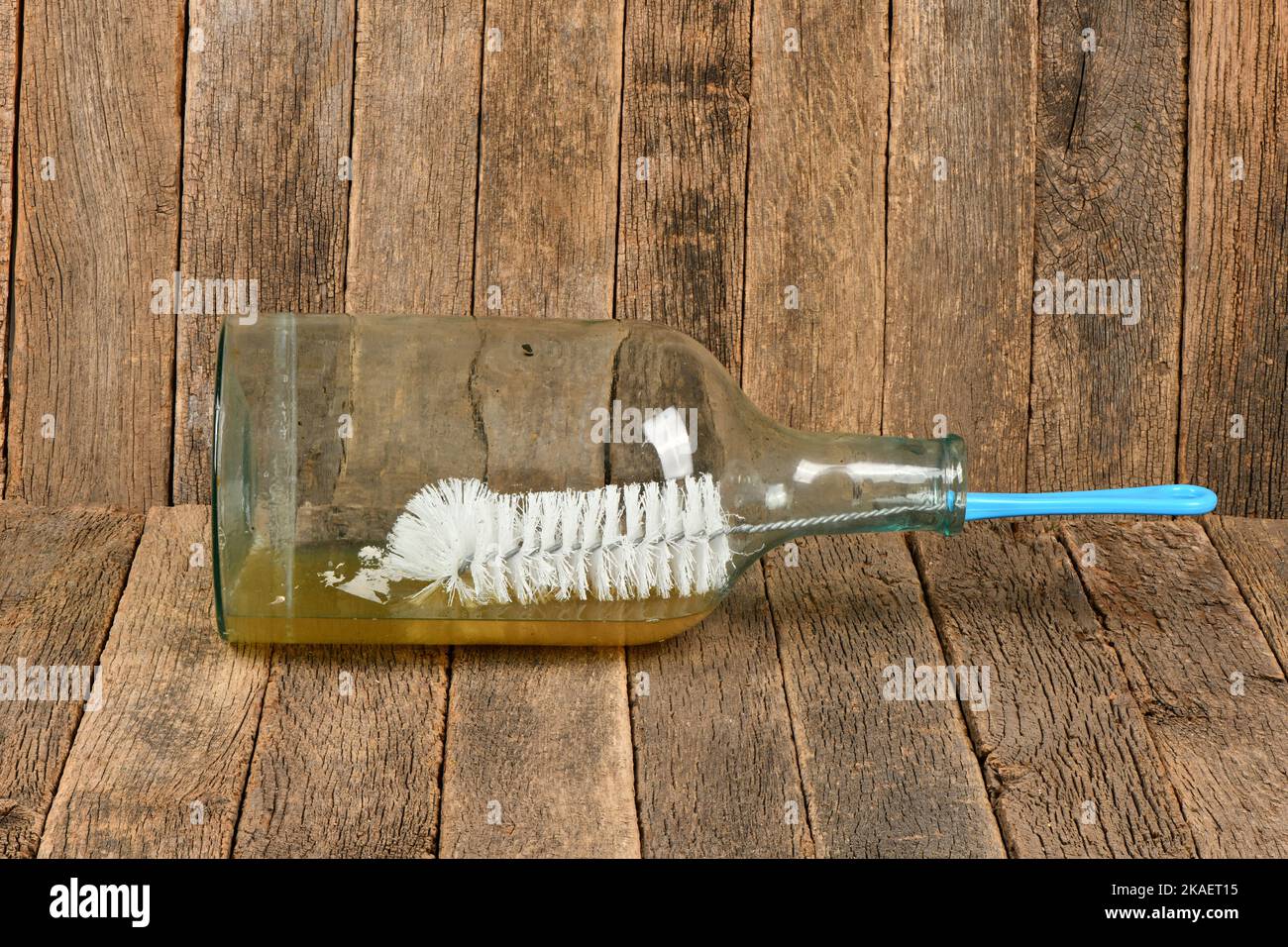 Wire brush for cleaning bottles isolated on dark wood background. Brush ...