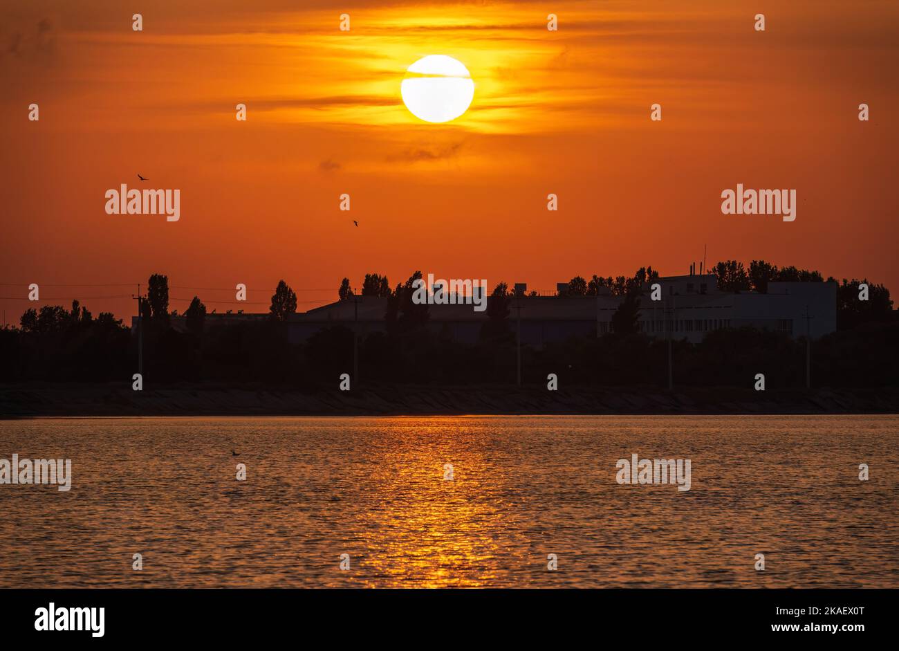 The sun goes down over a lake. Dramatic Sunset Sky Stock Photo - Alamy