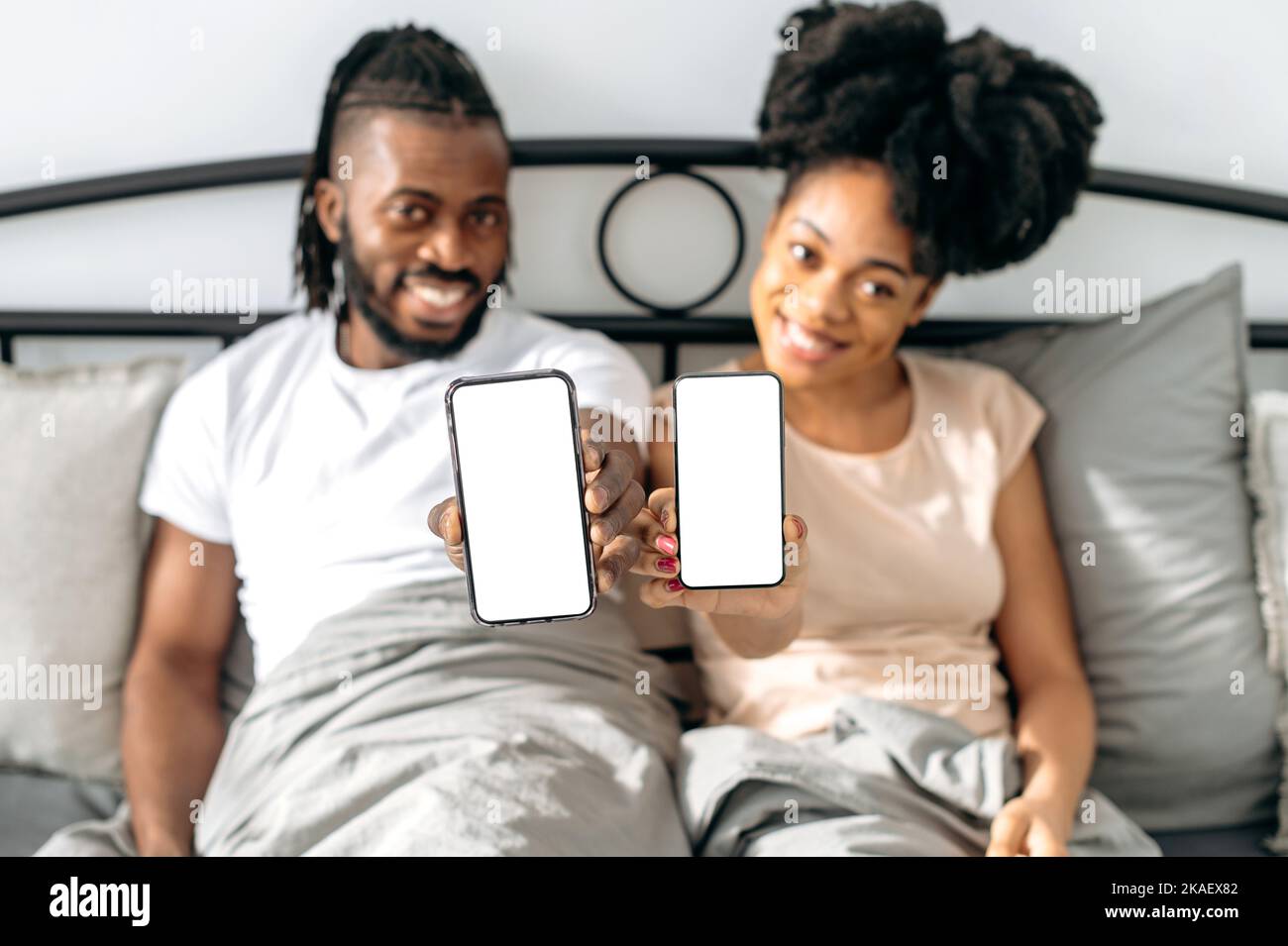 Joyful positive African American couple, happy spouses, sit in a cozy ...
