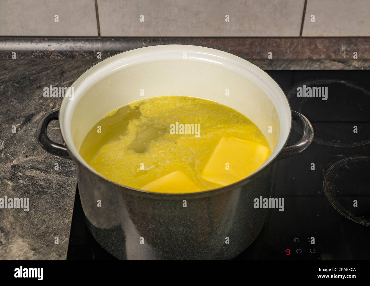 Cooking of marijuana butter in hot water on electric black cooker in ...