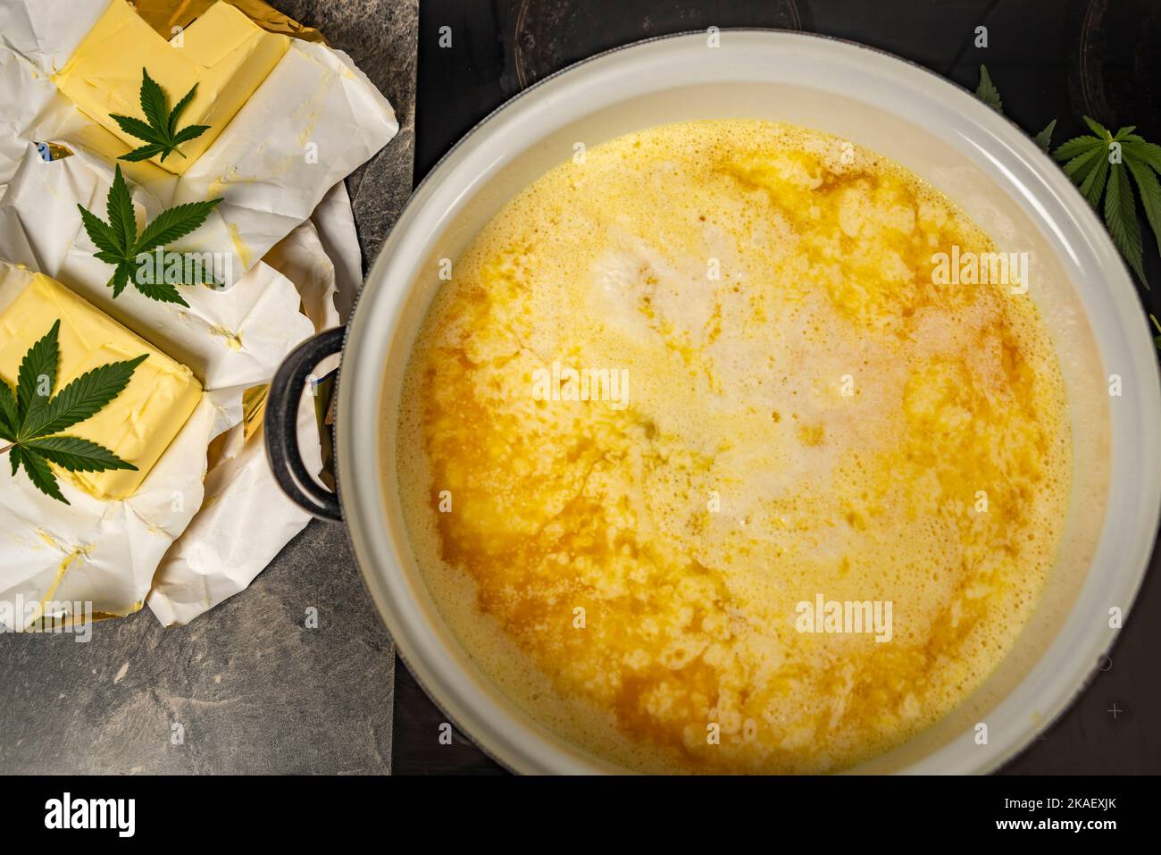 Cooking of marijuana butter in hot water on electric black cooker in ...