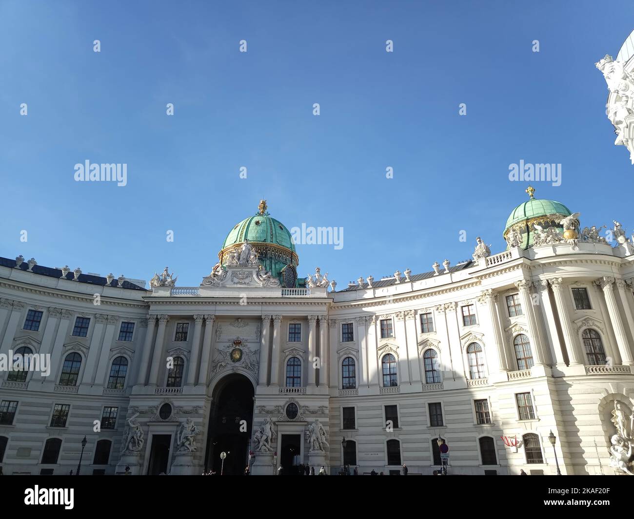 A wide angle shot of The Hofburg palace facade on blue sky background ...