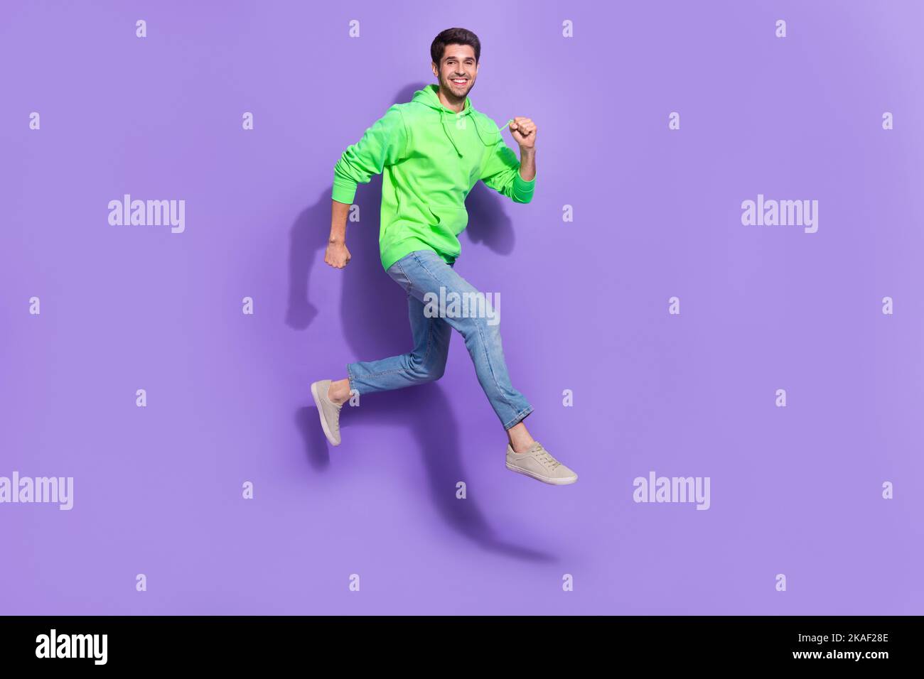 Full length photo of good mood man wear green jumping high running fast ...
