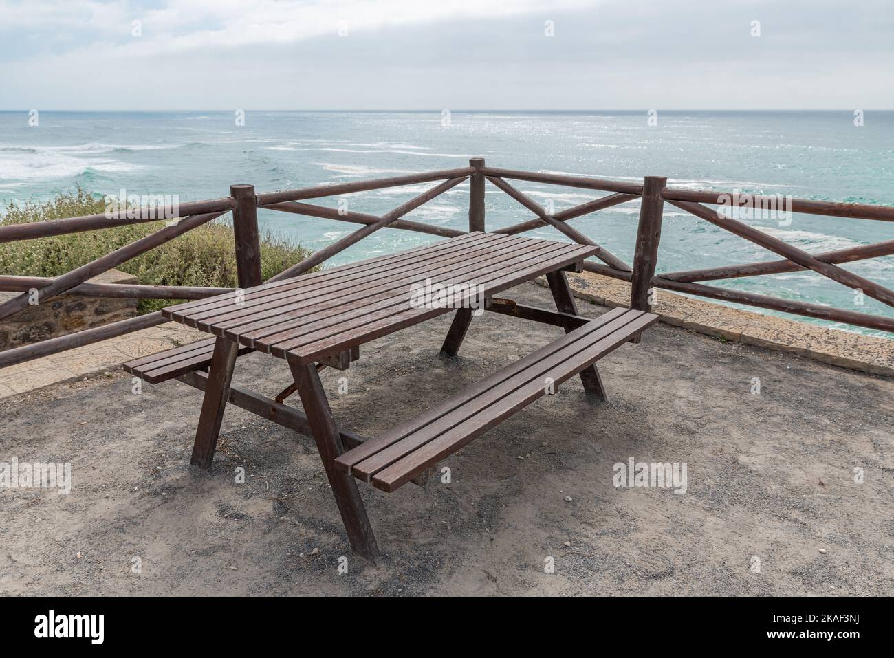 A wooden picnic table overlooking the ocean Stock Photo - Alamy