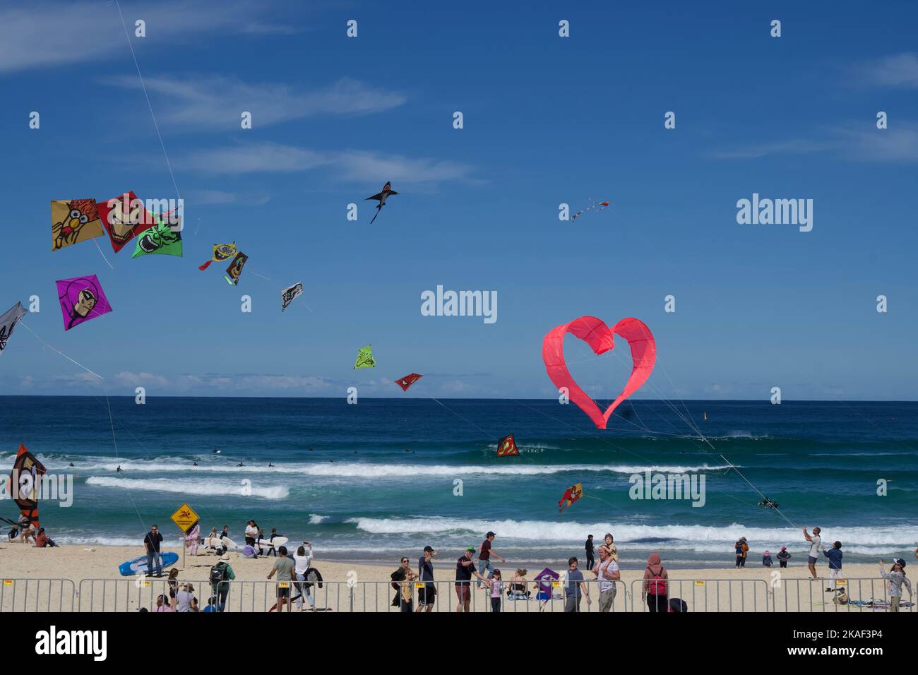 A kite festival with many colorful kites in the sky at Bondi beach ...
