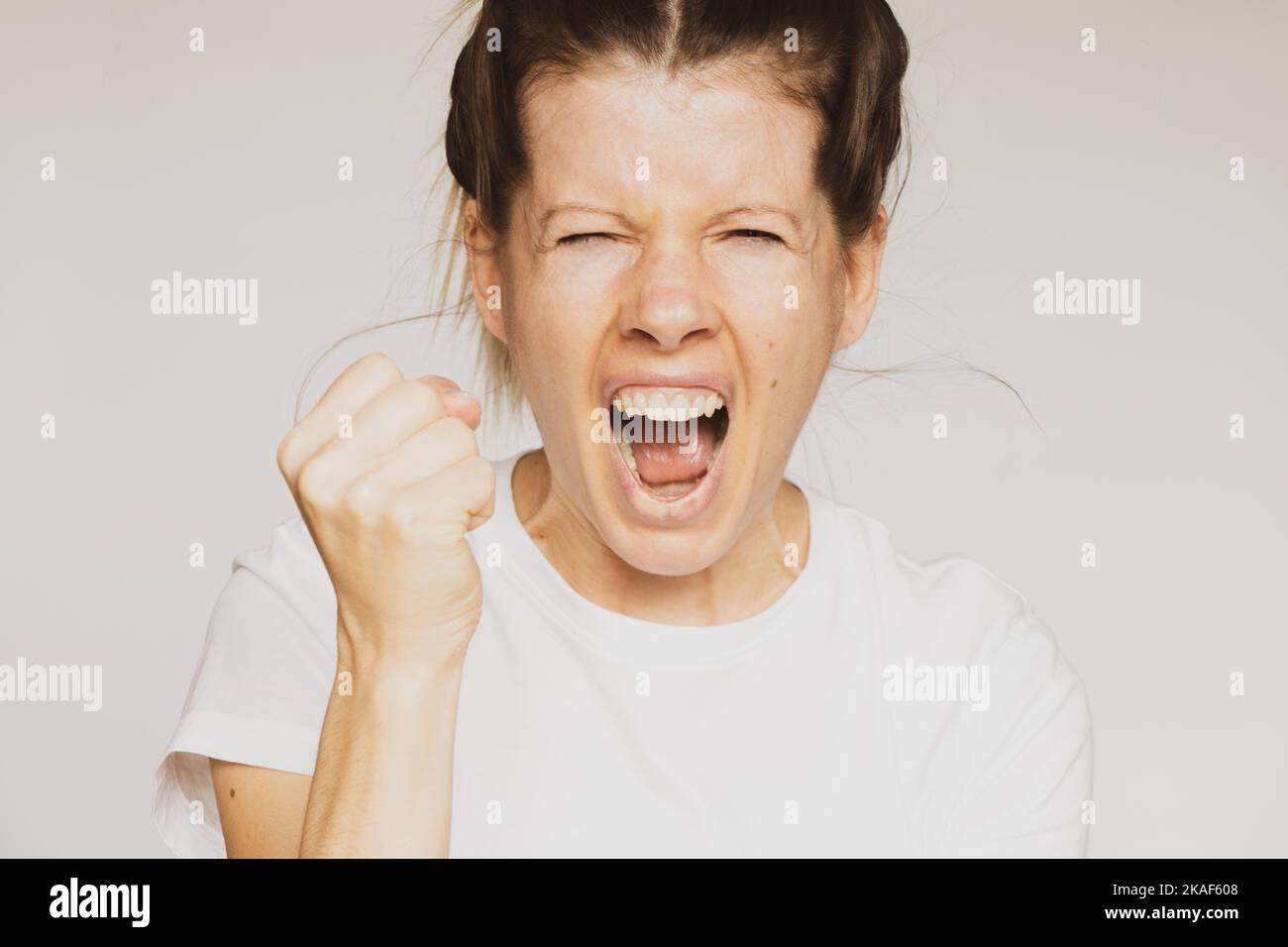 Girl screaming and waving her fist over isolated background closeup,bad day and no mood Stock ...