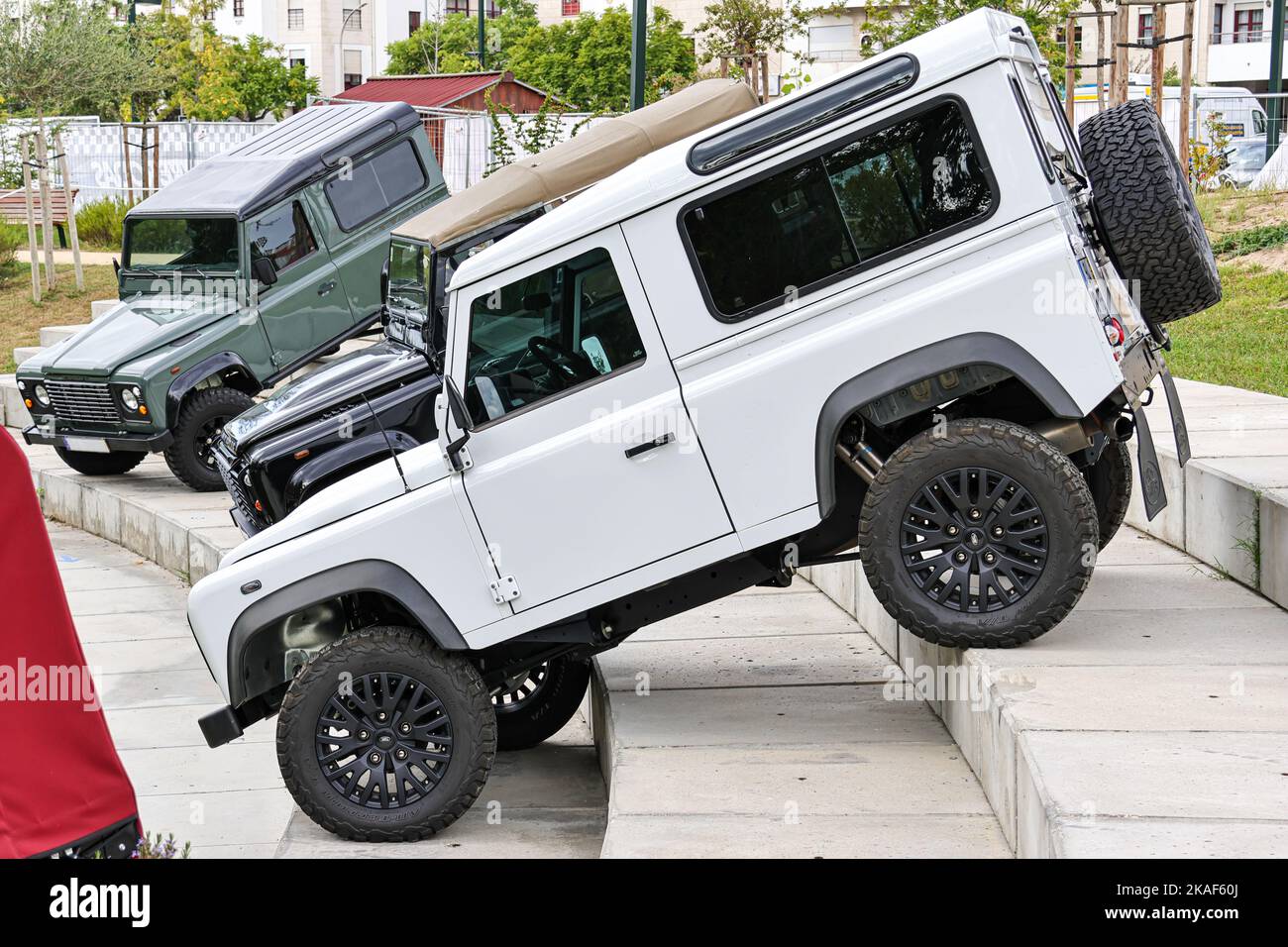 A row of Land Rover Defender off-road jeeps on concrete stairways ...