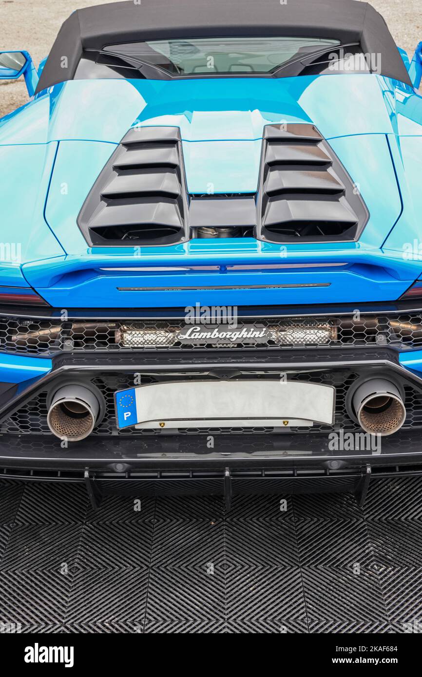 A vertical closeup of a blue sports car Lamborghini standing on the ...