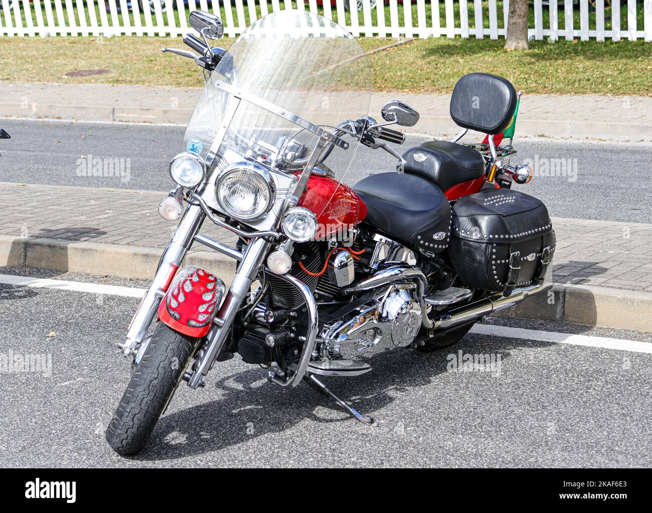 A beautiful red and chrome Harley Davidson motorcycle parked on a road ...