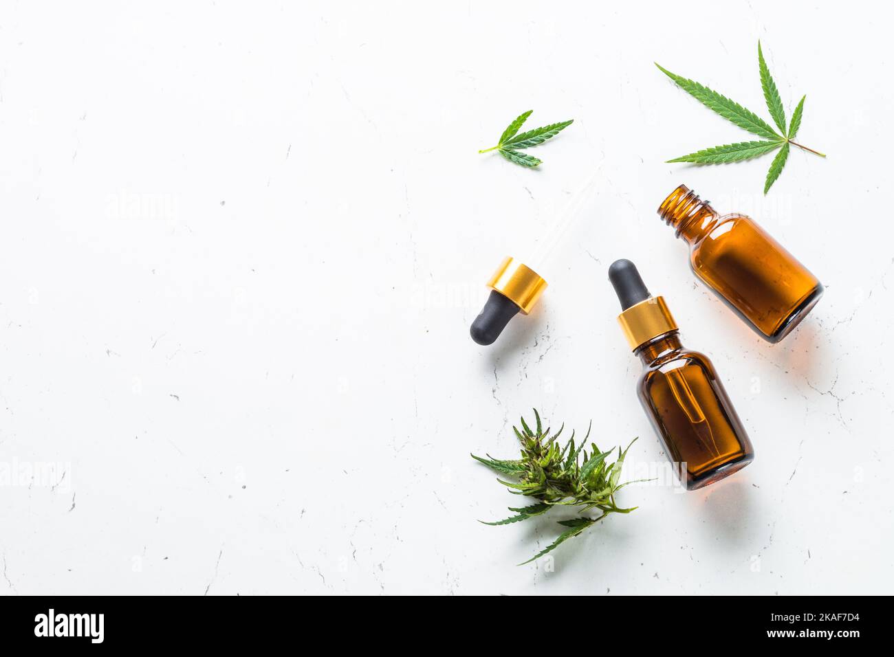 CBD oil and cannabis leaves at white table Stock Photo - Alamy
