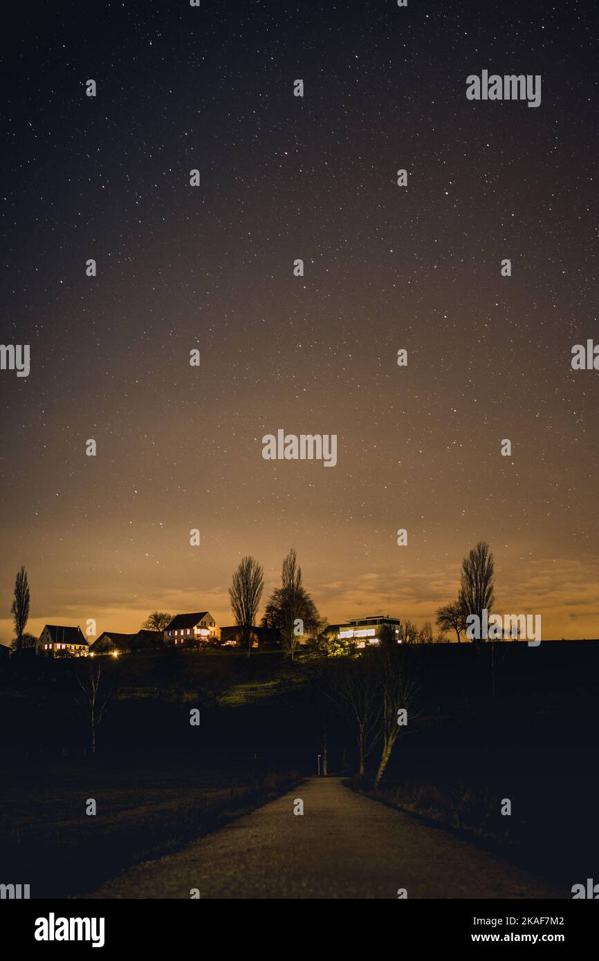 A vertical shot of a Night with stars over hill houses in Basel ...