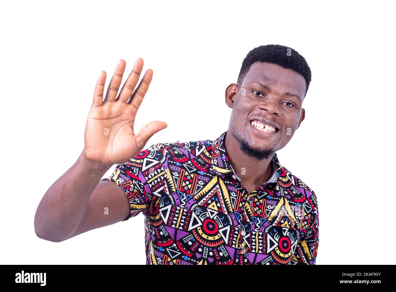 portrait happy young man raising his hand to greet while smiling at the ...