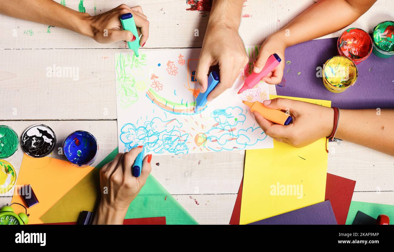 Markers in male and female hands draw on white paper Stock Photo - Alamy