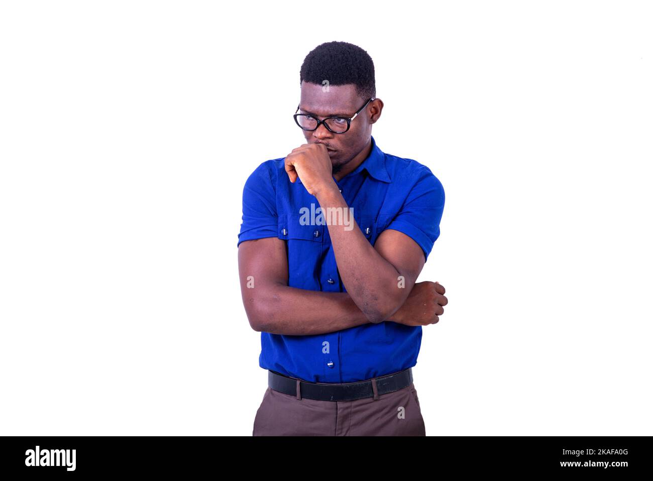 pensive young man wearing optical glasses, looking sideways with folded ...