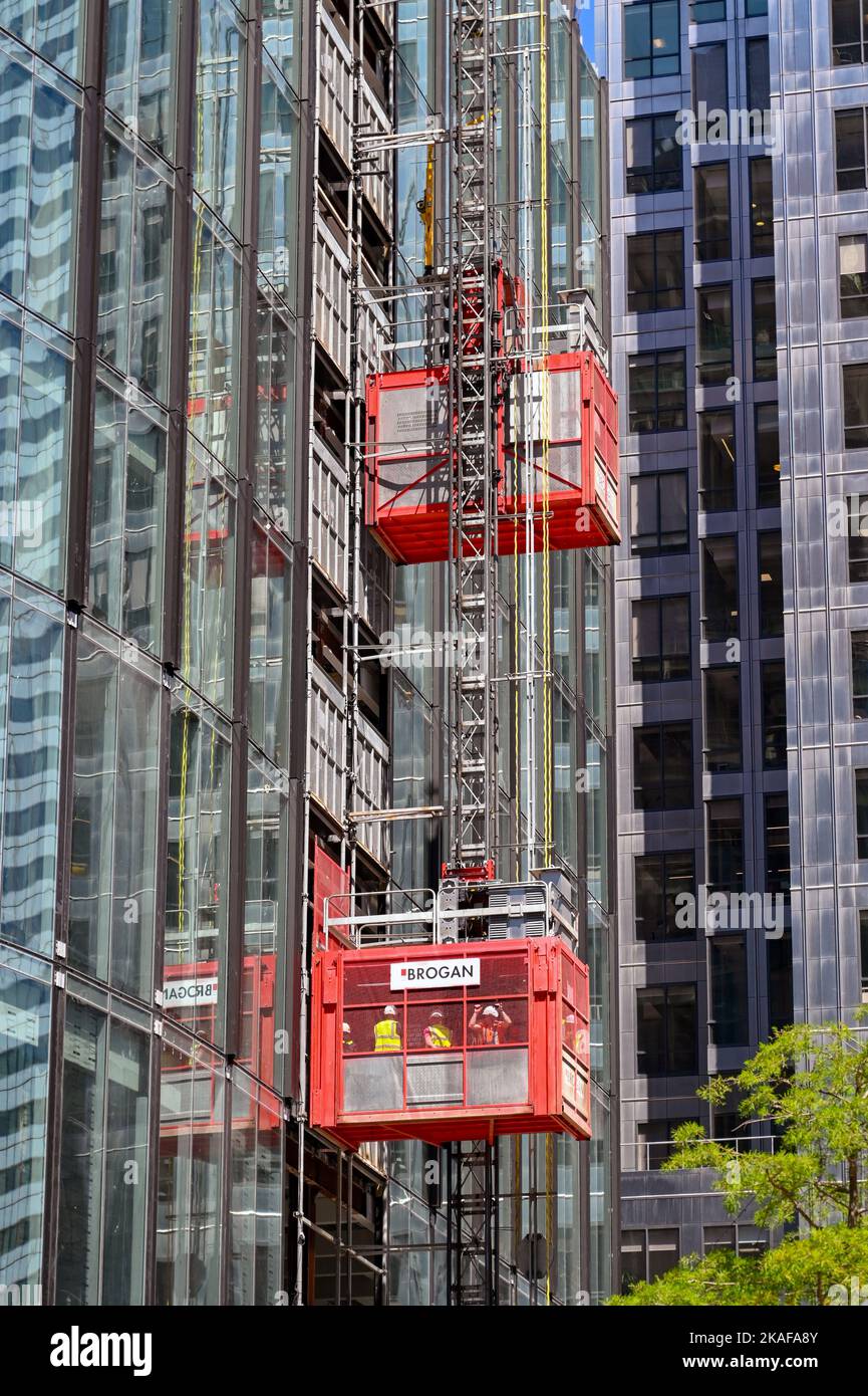 London, England - June 2022: Construction workers riding an elevator on ...