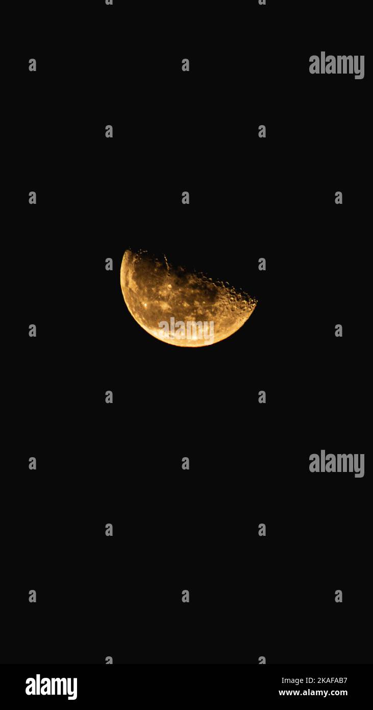 A vertical closeup of a half moon in the dark night sky Stock Photo - Alamy