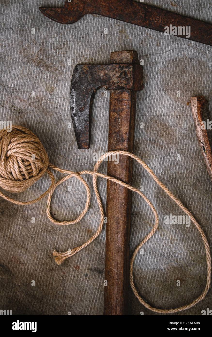 A flat-lay collection of vintage tools including an axe, a spanner and ...