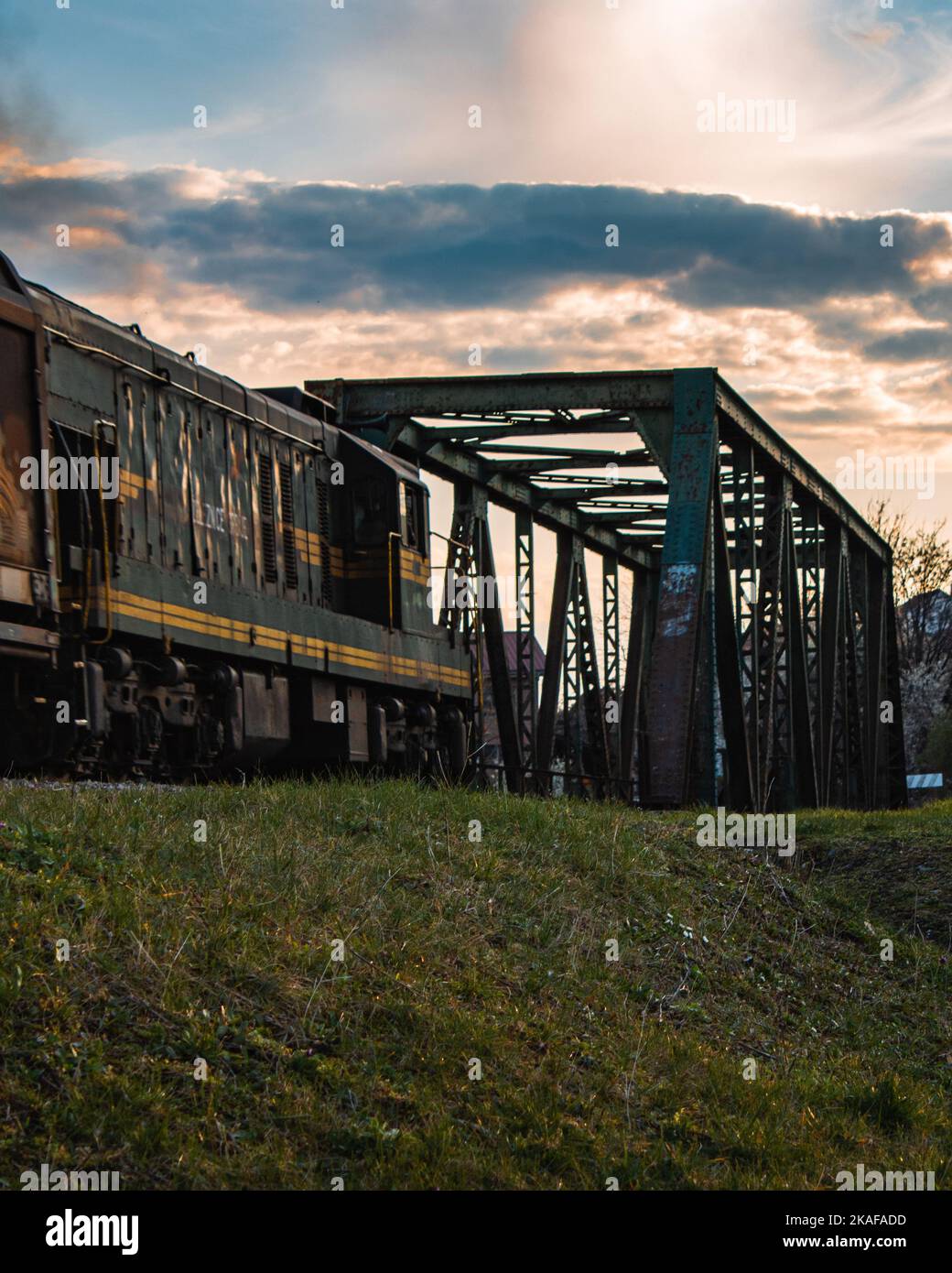 A side view of an rustic aged train on railway tracks at sunset Stock ...