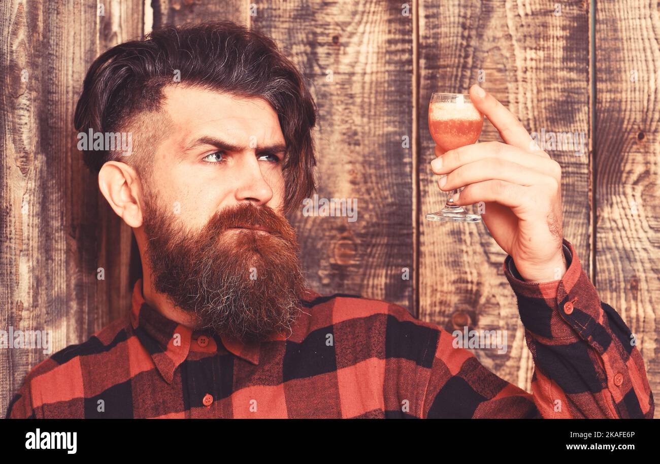 Man holds alcohol cocktail on wooden background Stock Photo - Alamy
