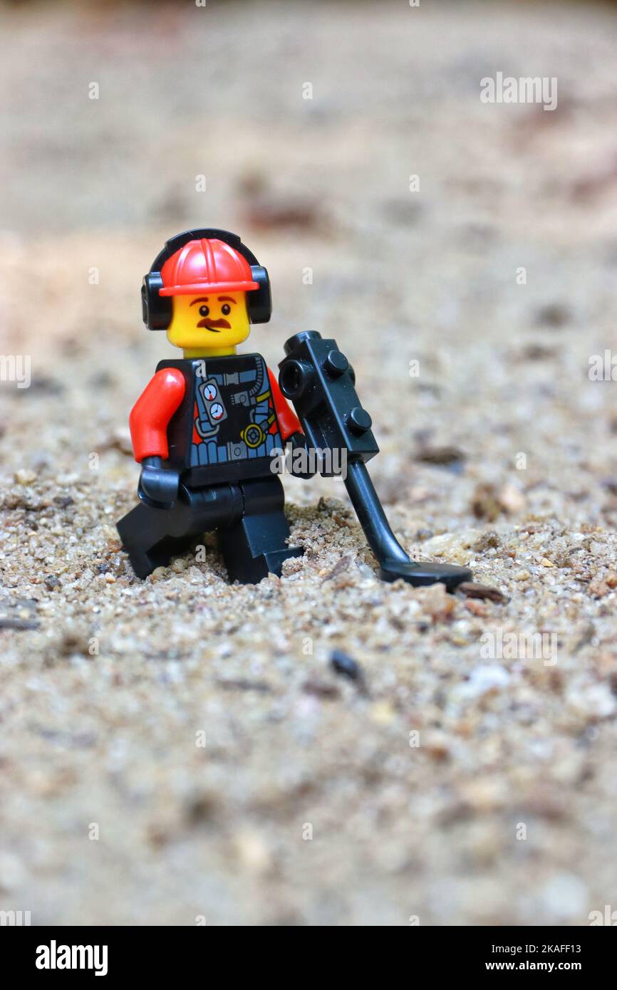 A Lego Toy male figure character with a moustache, walking in the sand ...