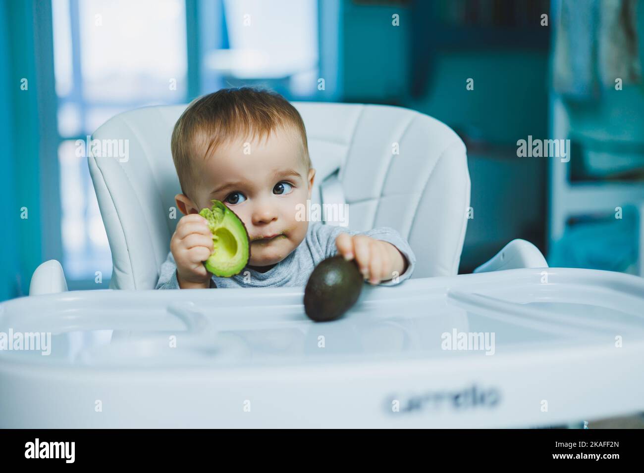Little adorable baby eating avocado. Vitamin and healthy food for small ...