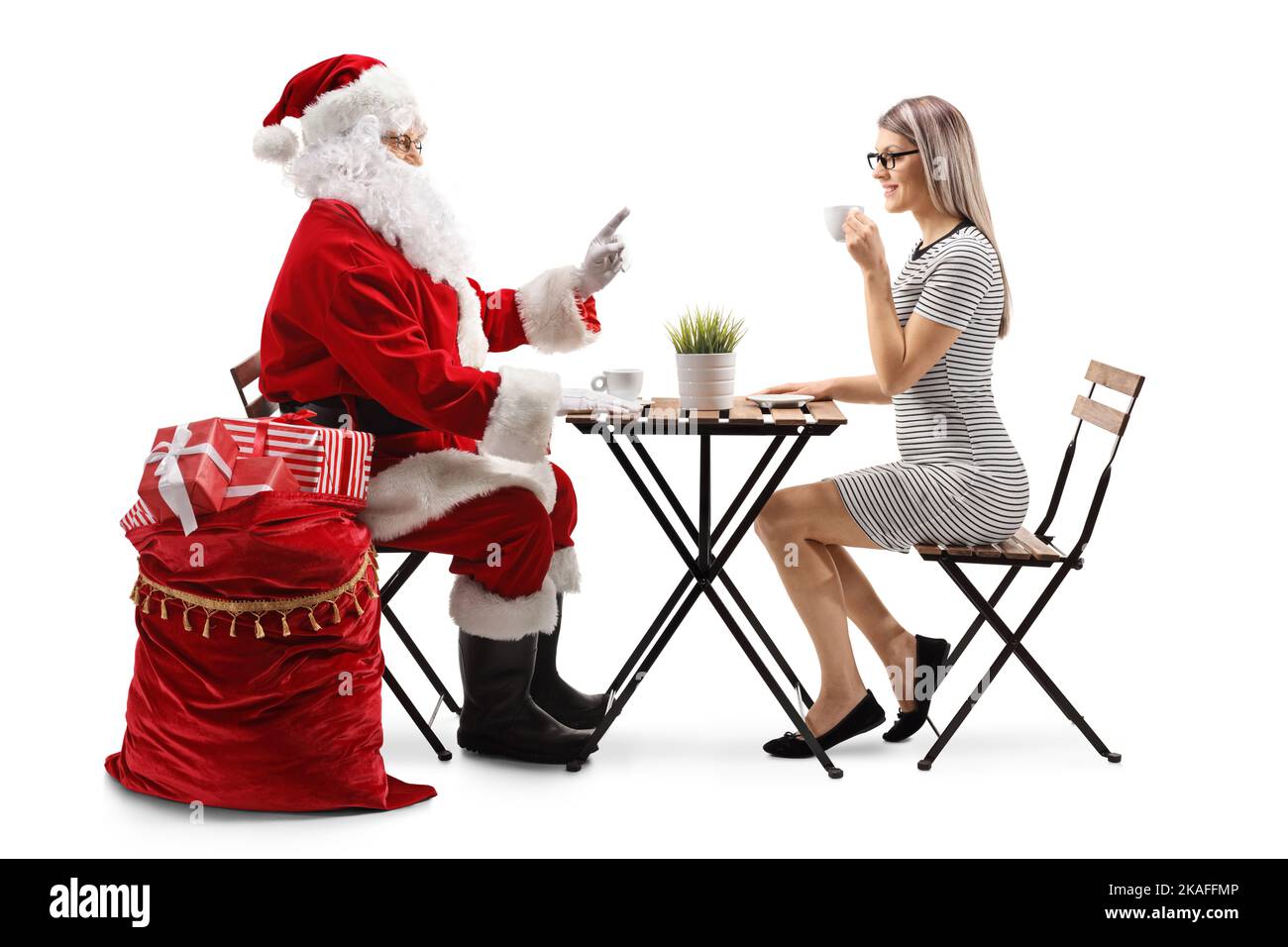 Santa Claus talking to a young female with a cup of coffee in a cafe ...