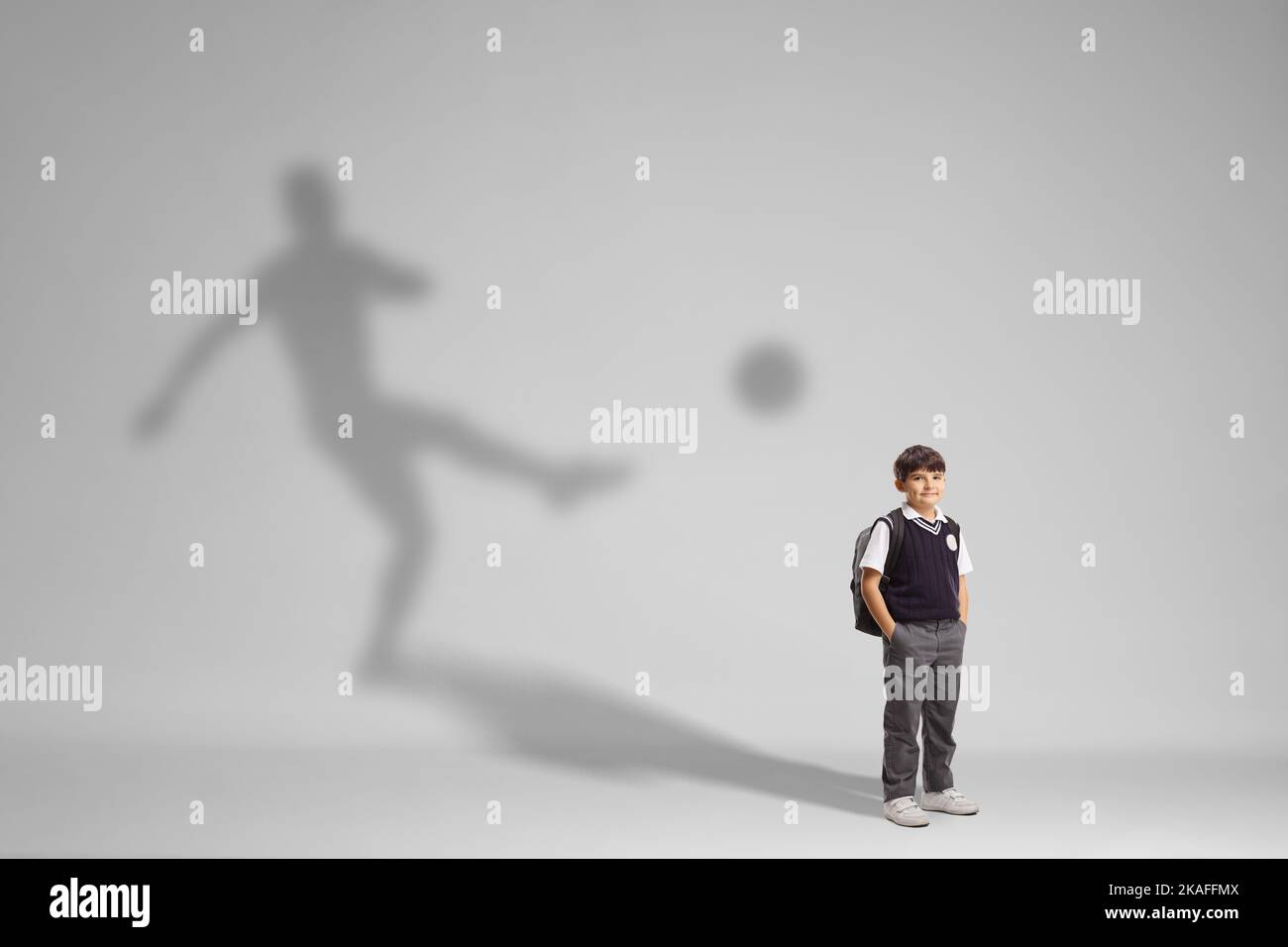 Schoolboy in a uniform imagining of becoming a football player with a ...