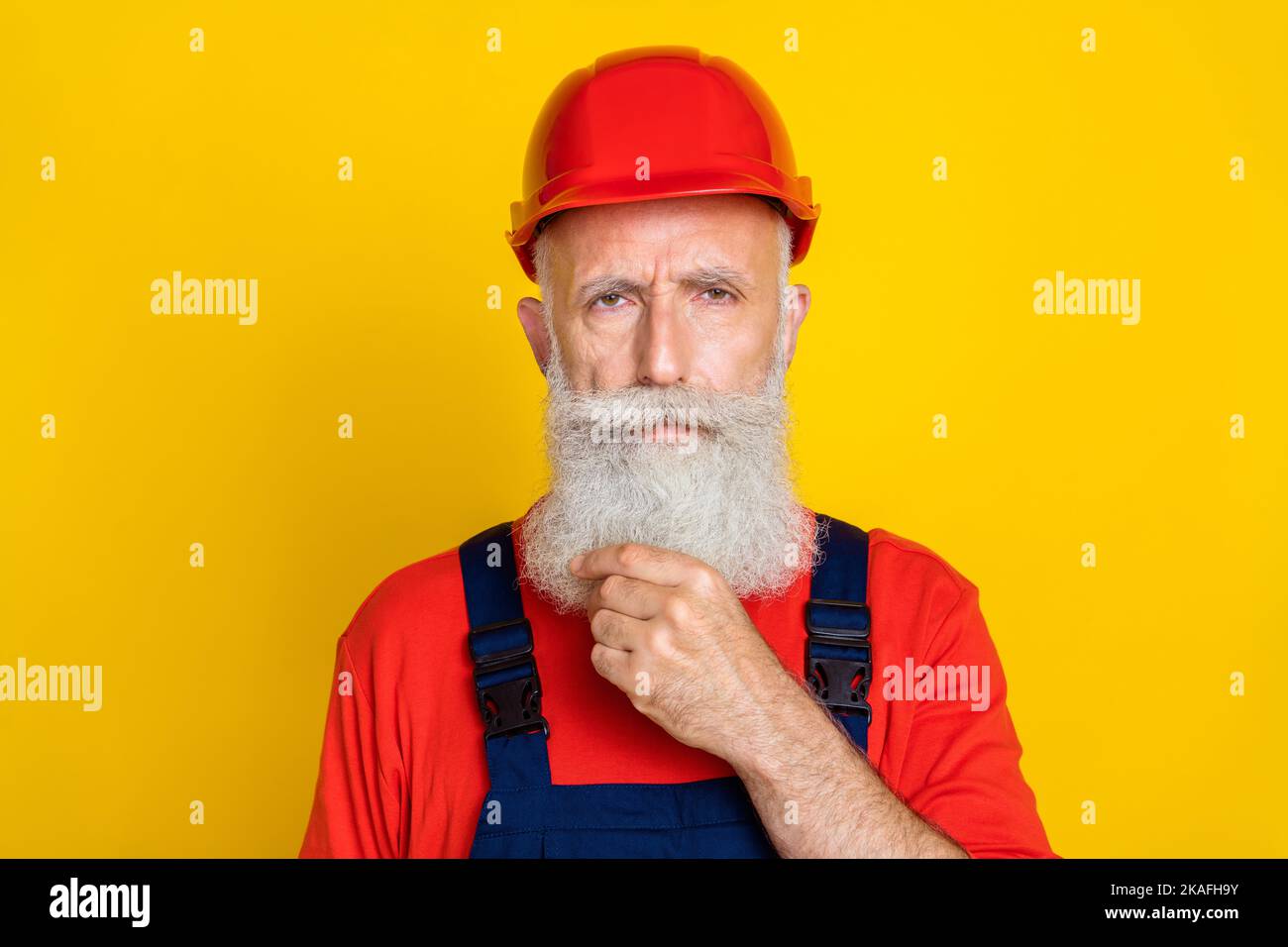 Photo of thoughtful confident age man workwear overall red hard hat arm ...