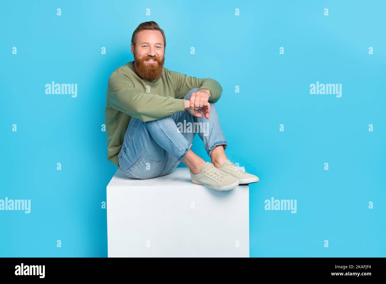 Full length photo of nice young man sit white cube platform cheerful ...