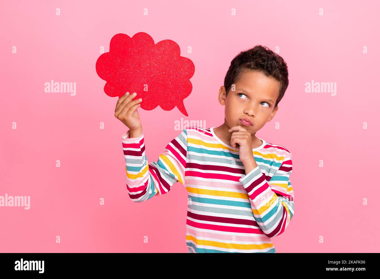 Portrait of minded boy striped pullover arm hold shiny cloud touch face ...