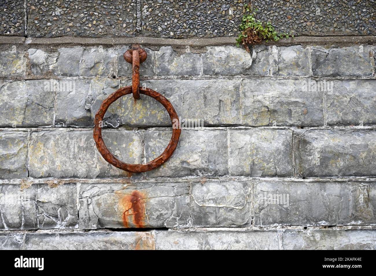 Old rusty metal mooring ring on an old wall. Metal rusty chain on ...