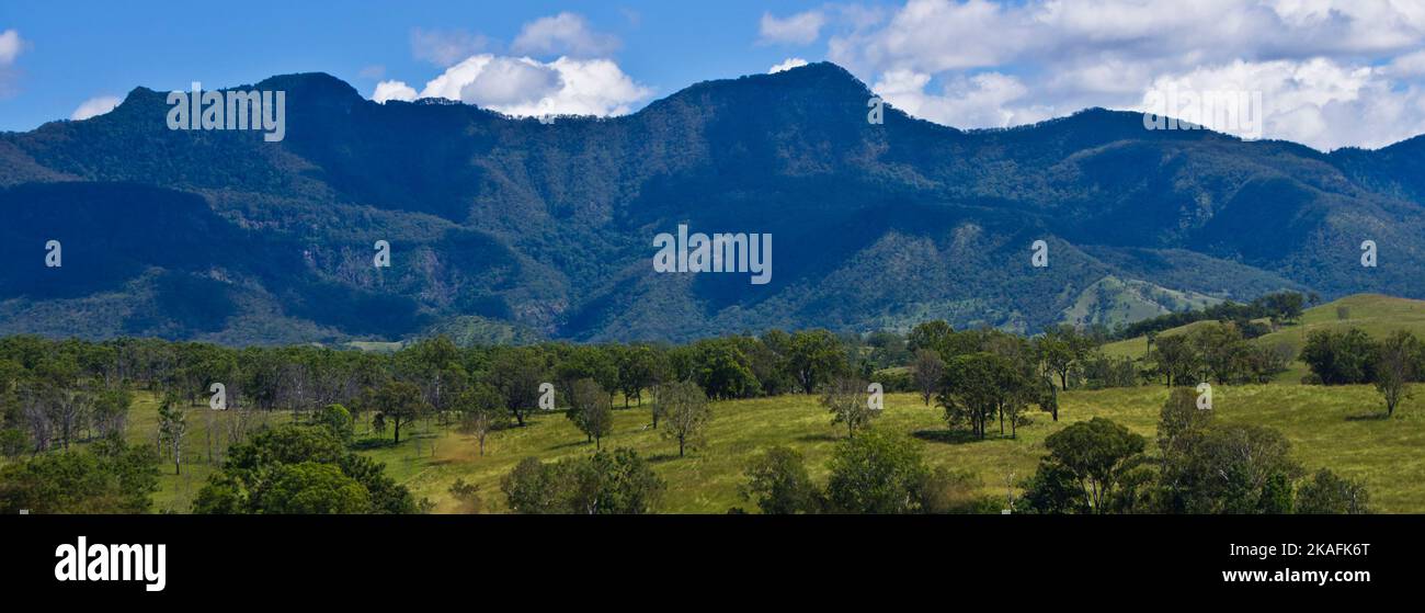 Green fields with mountains behind Stock Photo - Alamy