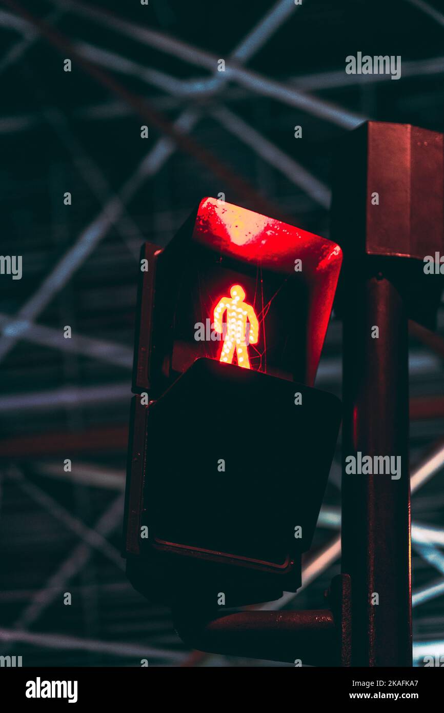 A vertical shot of a pedestrian traffic light with the illuminated red ...