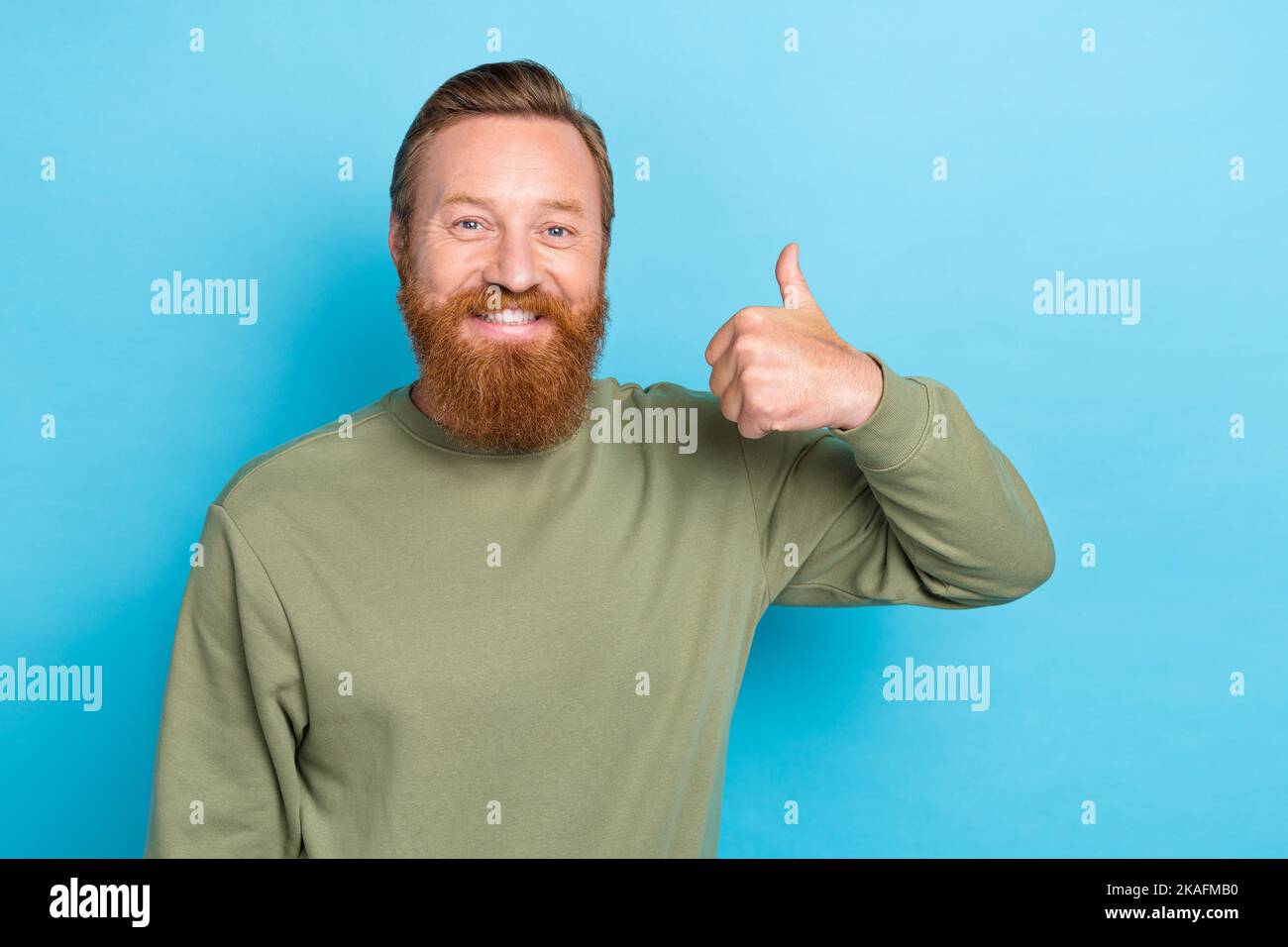 Photo portrait of nice young man showing thumb up cheerful good mood ...