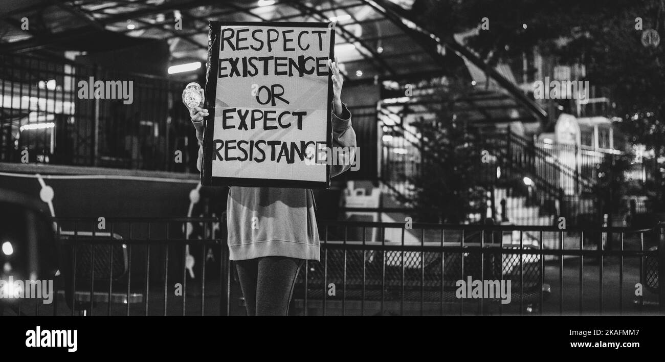 A grayscale of a protest sign with editable text being held by a young ...