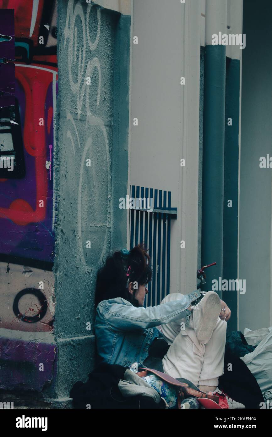 A vertical shot of a woman sitting on the ground and leaning on the ...