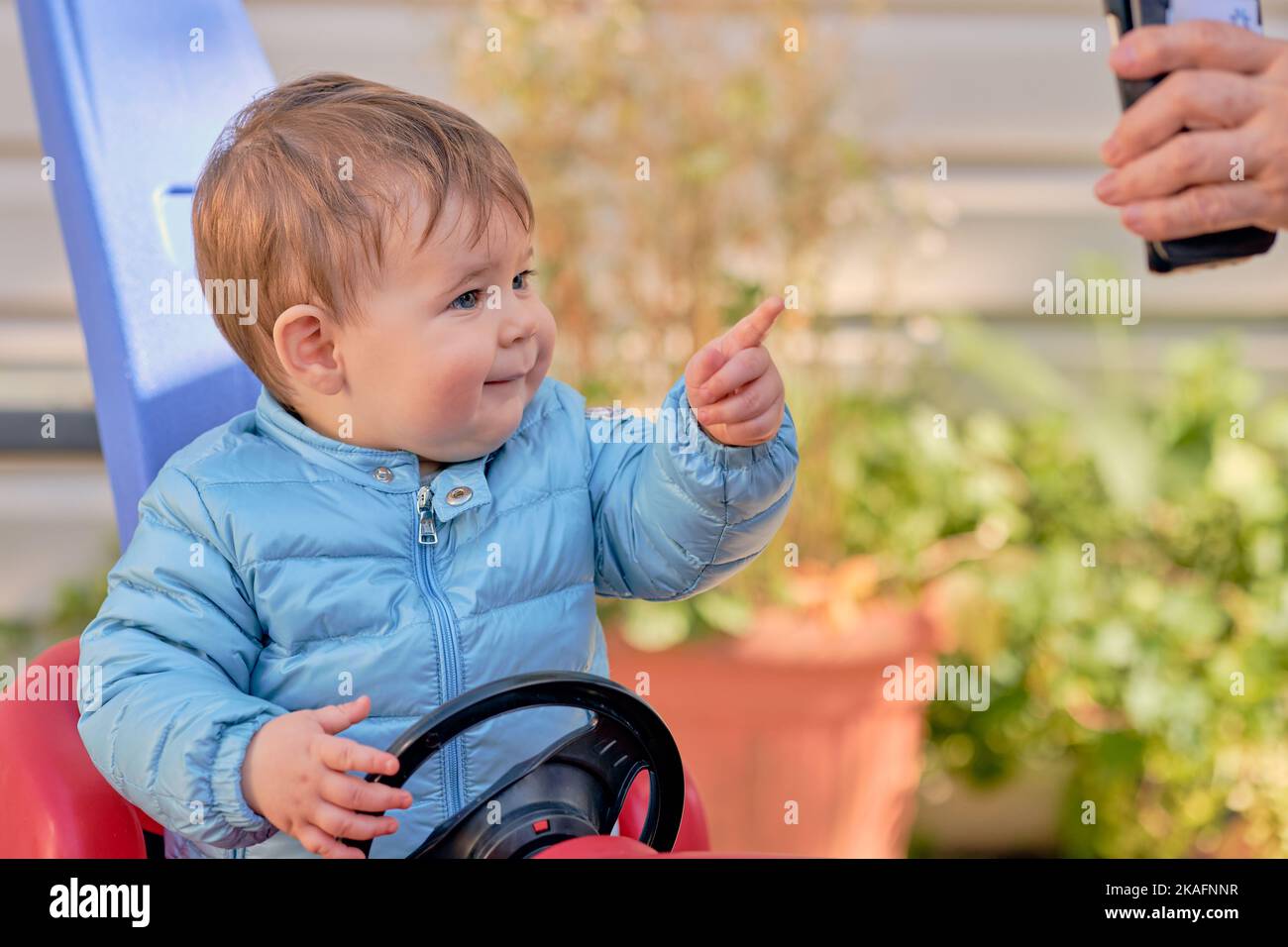 boy toddler in his push car interacting with family via video ...