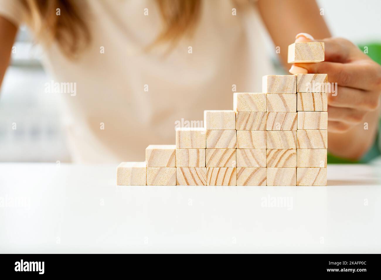 Woman hand arranging wood block stacking as step stair Stock Photo - Alamy