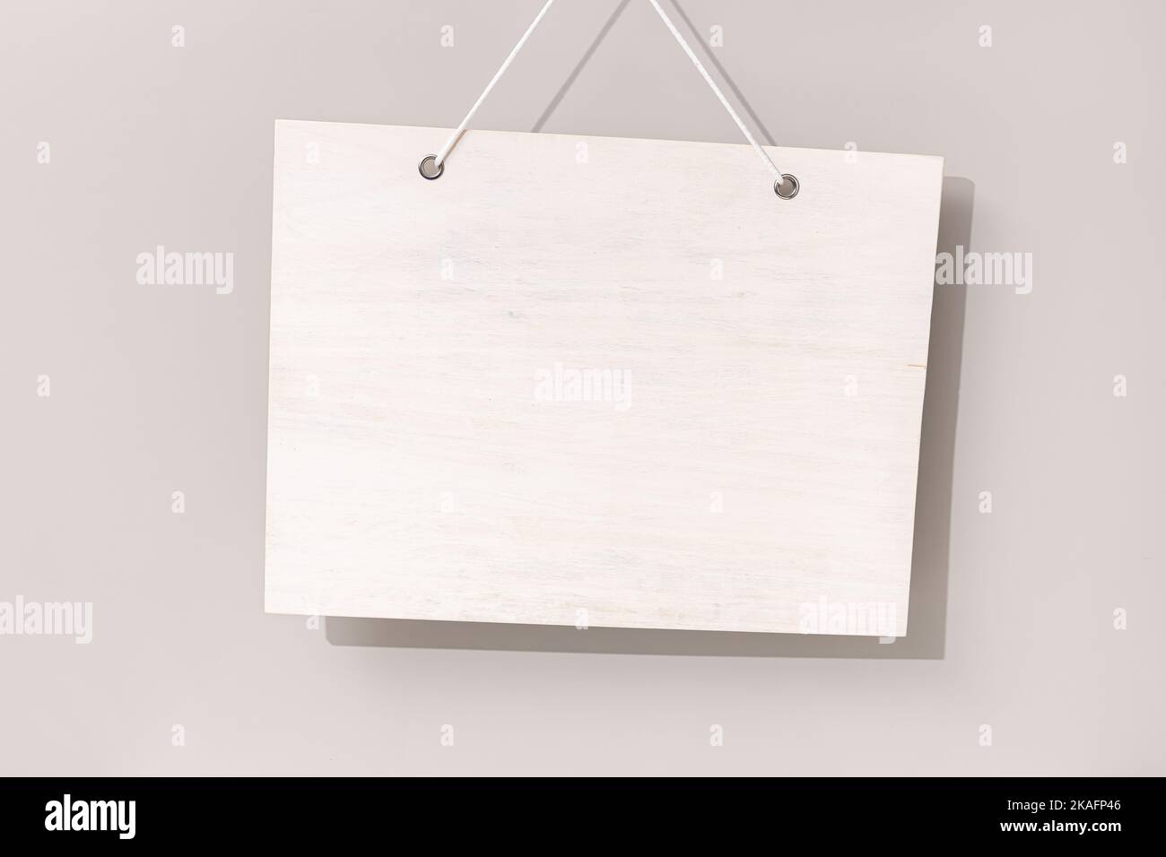 Blank white bleached wooden sign hanging on beige background. Mock up ...