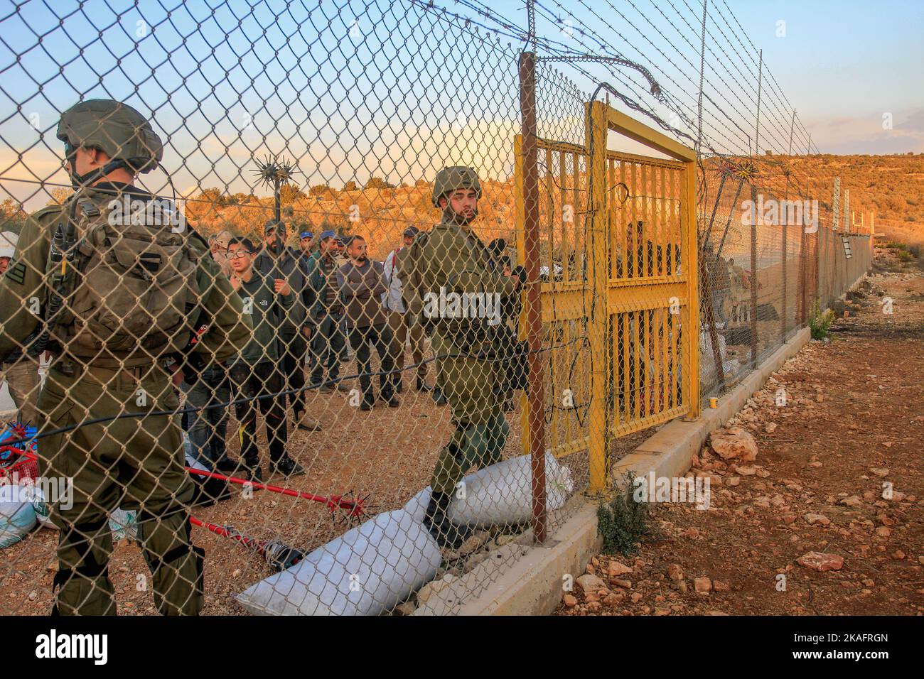 An Israeli soldier opens the gate of the separation barrier in the ...
