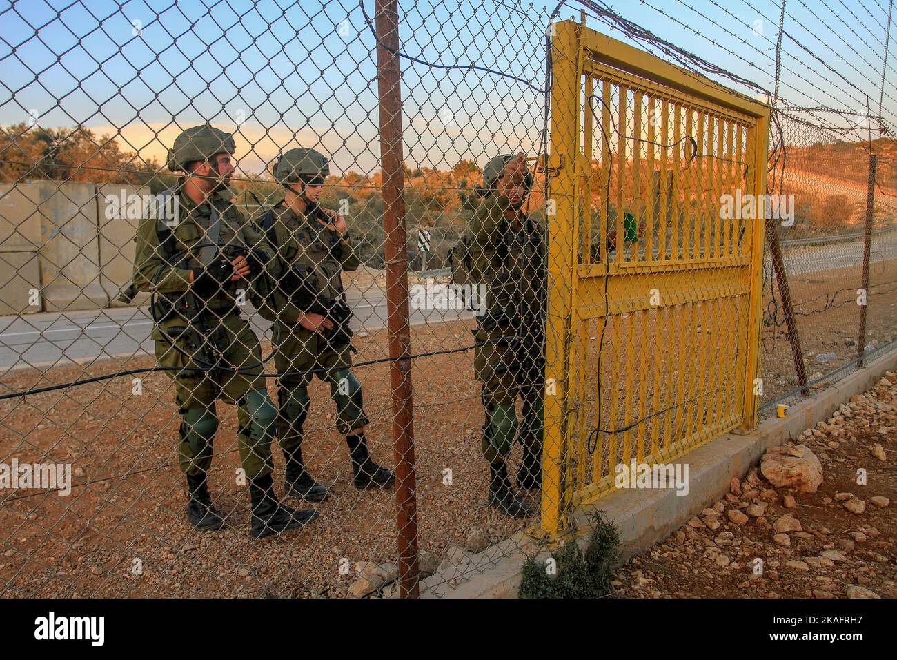 An Israeli soldier opens the gate of the separation barrier in the ...
