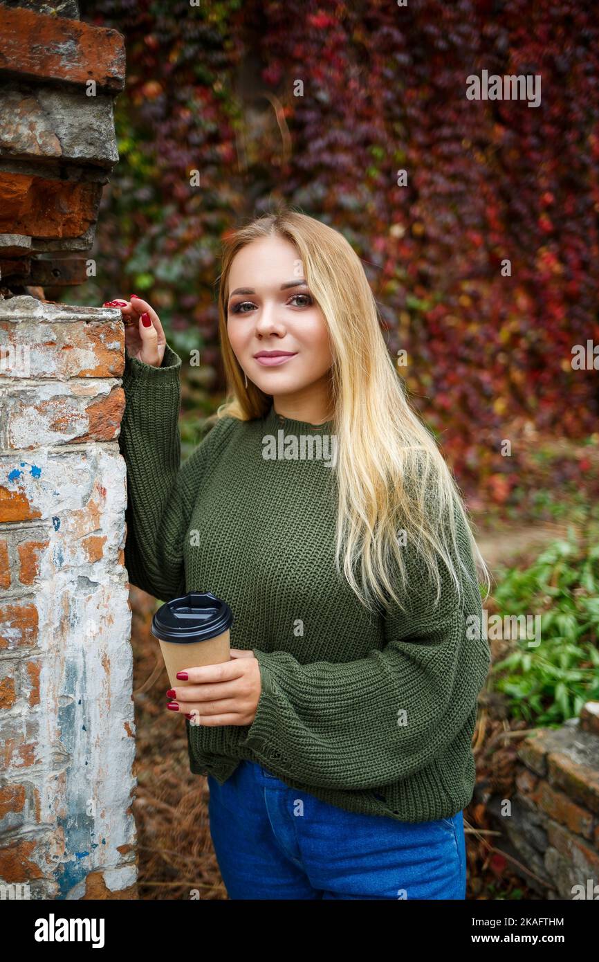 Walk of a beautiful girl in a sweater and jeans Stock Photo - Alamy