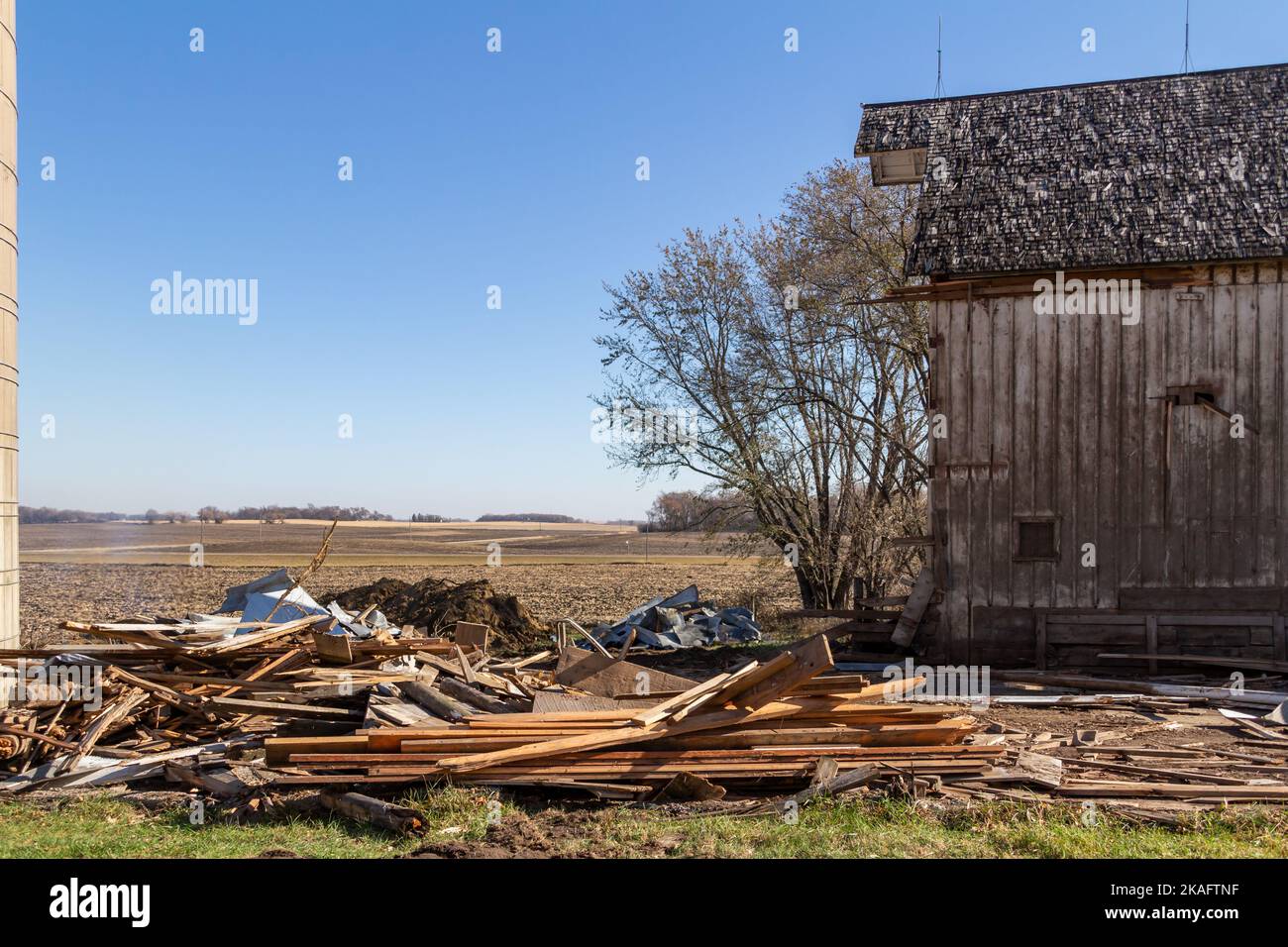 This image shows a close up exterior view of an old abandoned barn building in the beginning ...